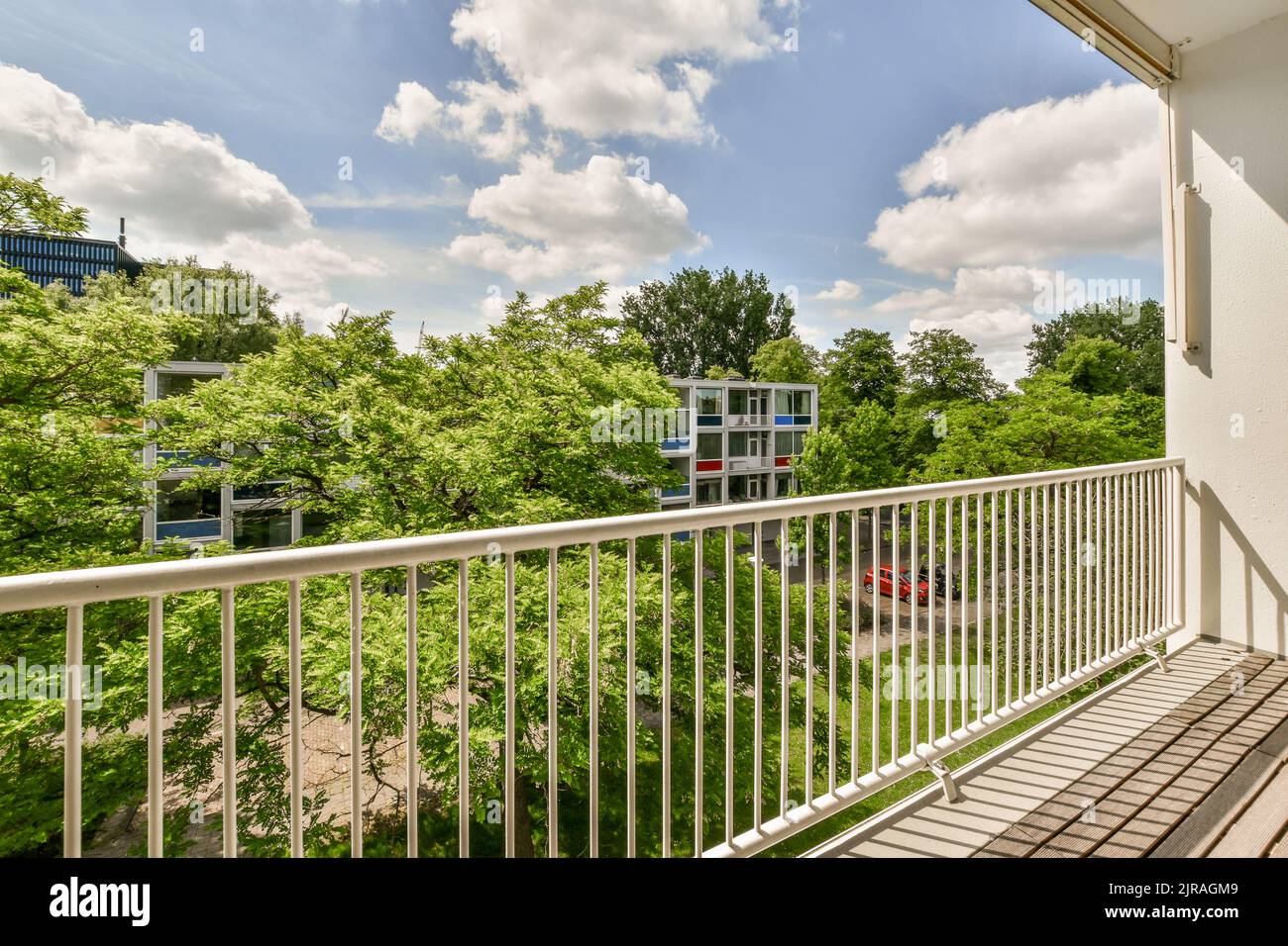Front view of buildings and cars from small balcony with railings Stock ...