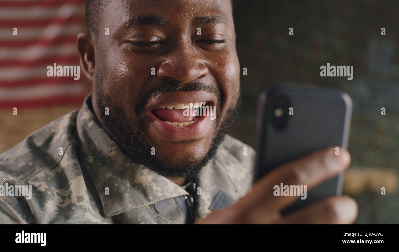Bearded black soldier smiling and waving hand while speaking with ...