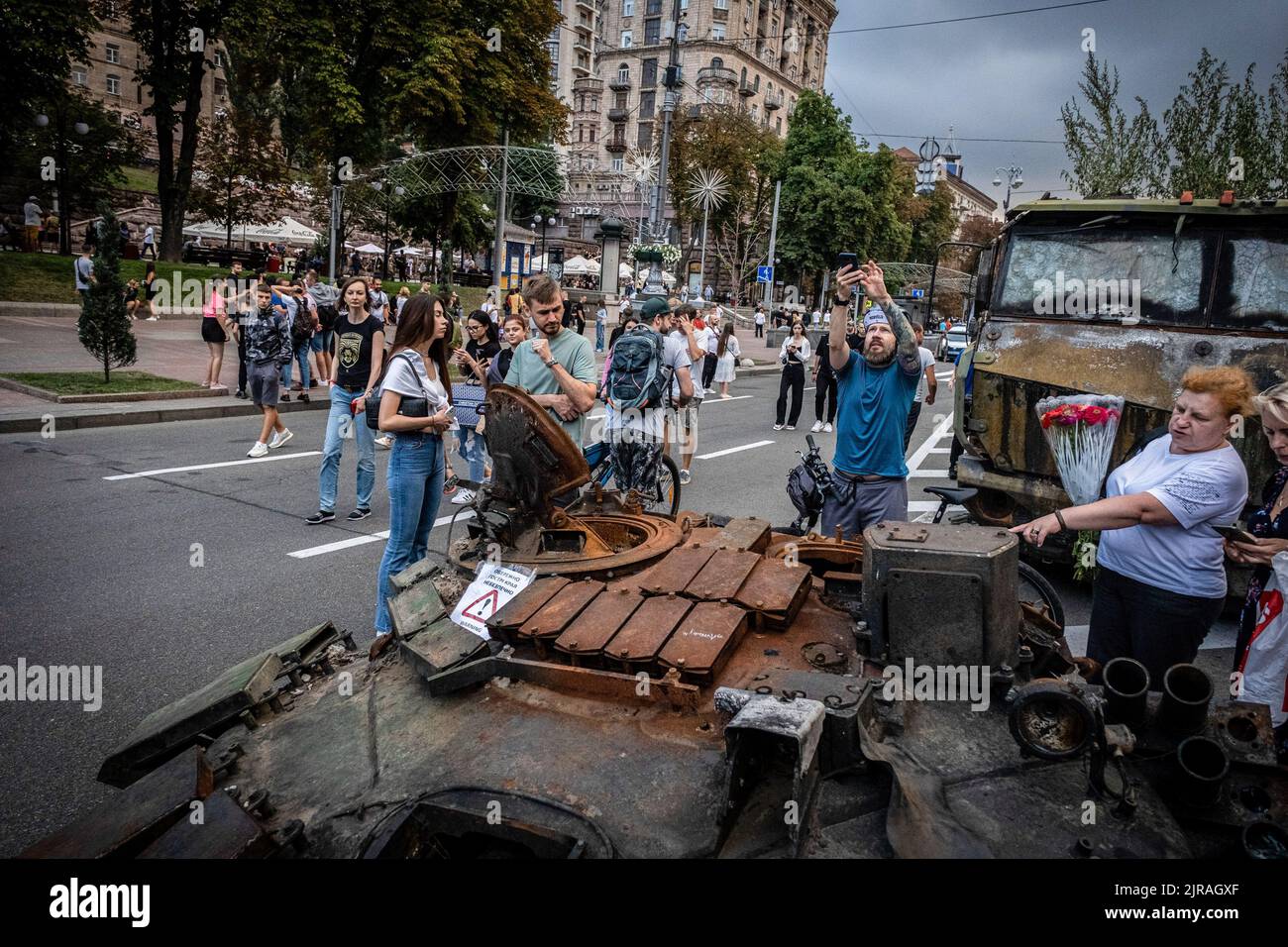 People observe the wreckage of a Russian tank turret in Kyiv, Ukraine ...