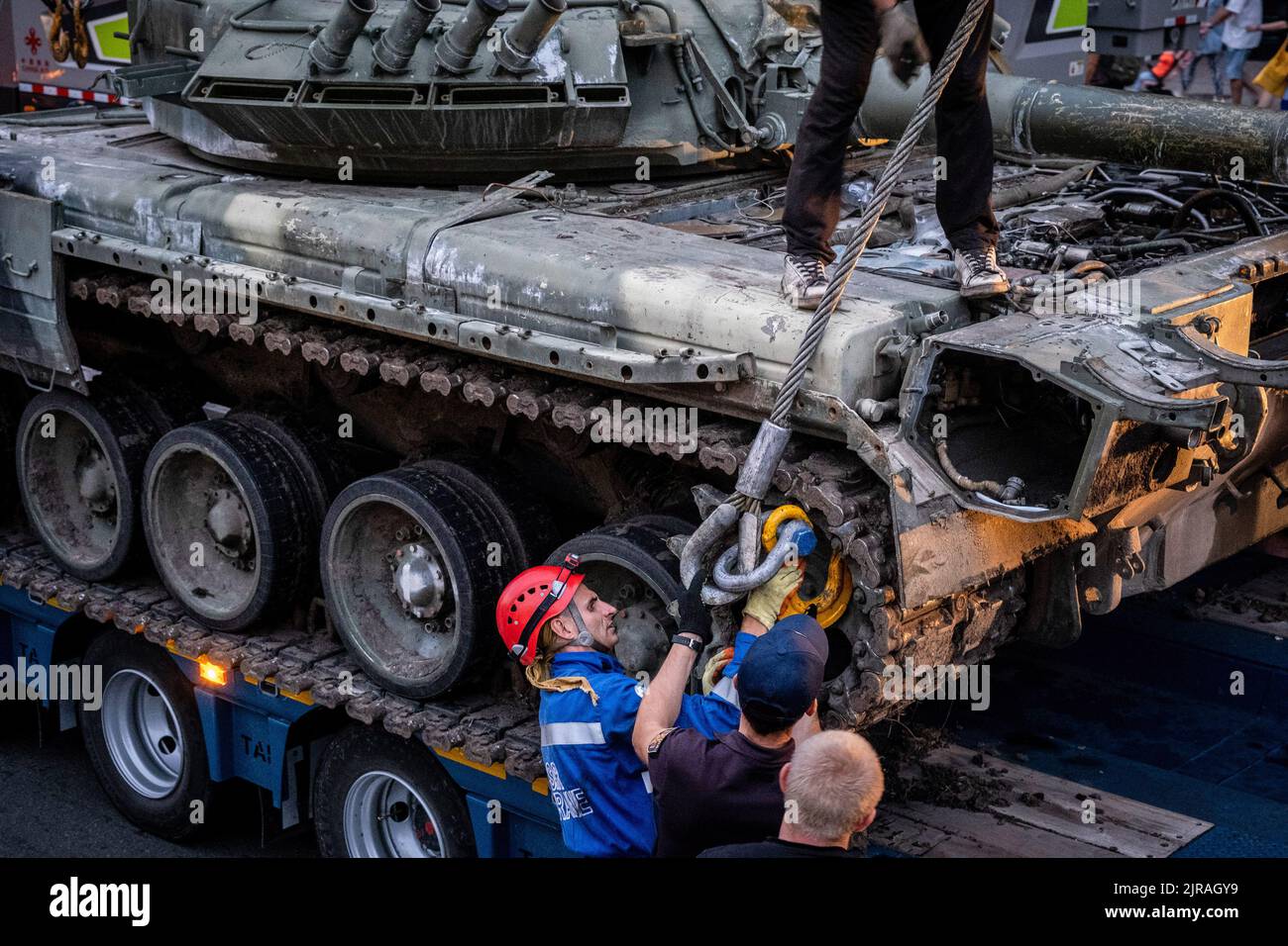 Workers transport the wreckage of the Russian tank to the exhibition ...