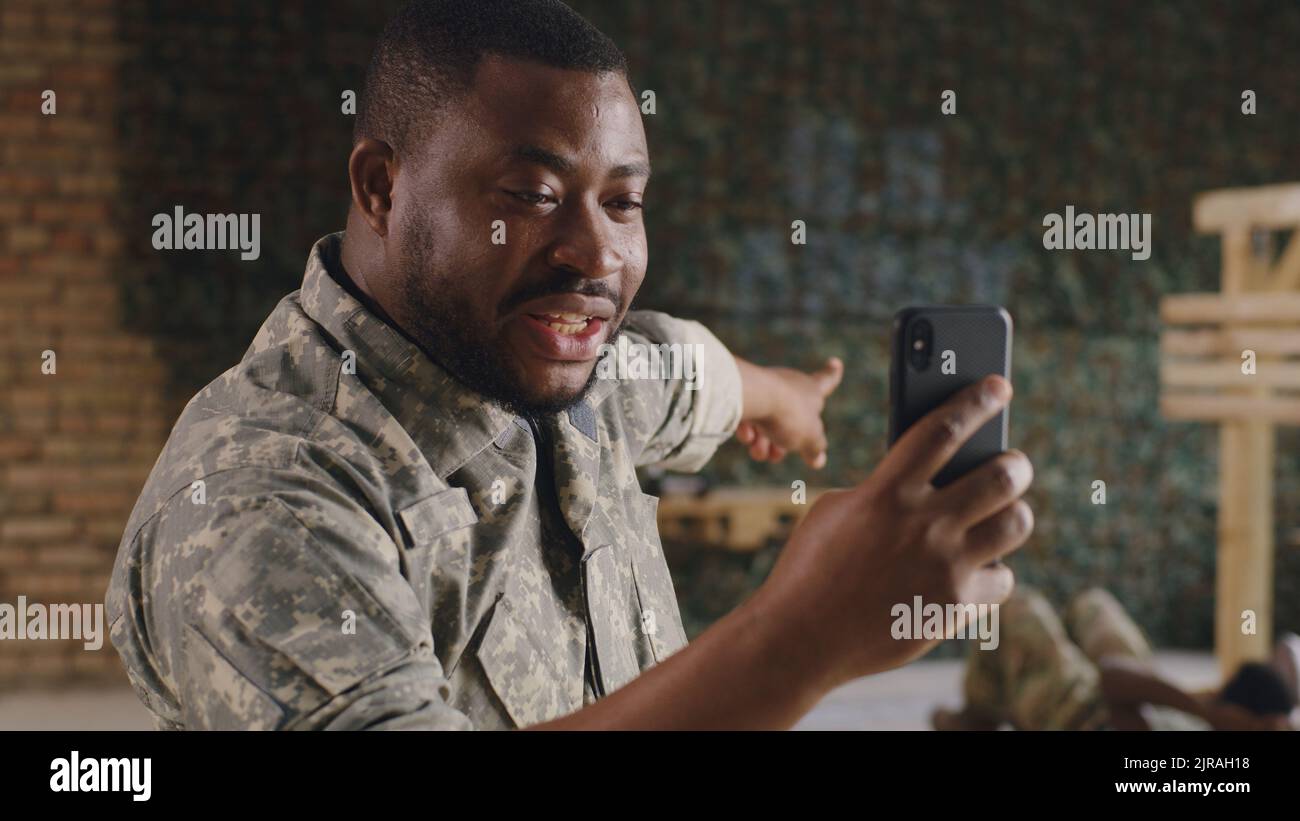 African American commander in camouflage speaking and pointing at ...