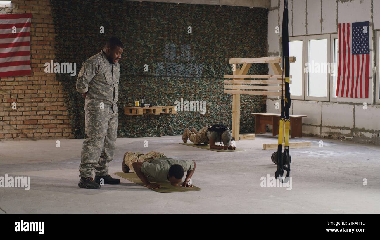 African American man in camouflage walking and giving instructions to ...