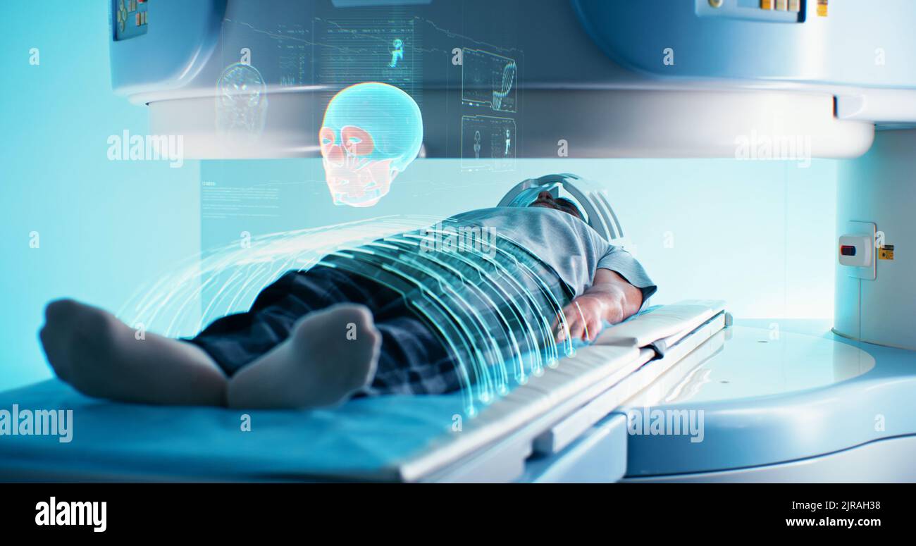 Senior man lying on table of MRI machine with emerging HUD interface ...