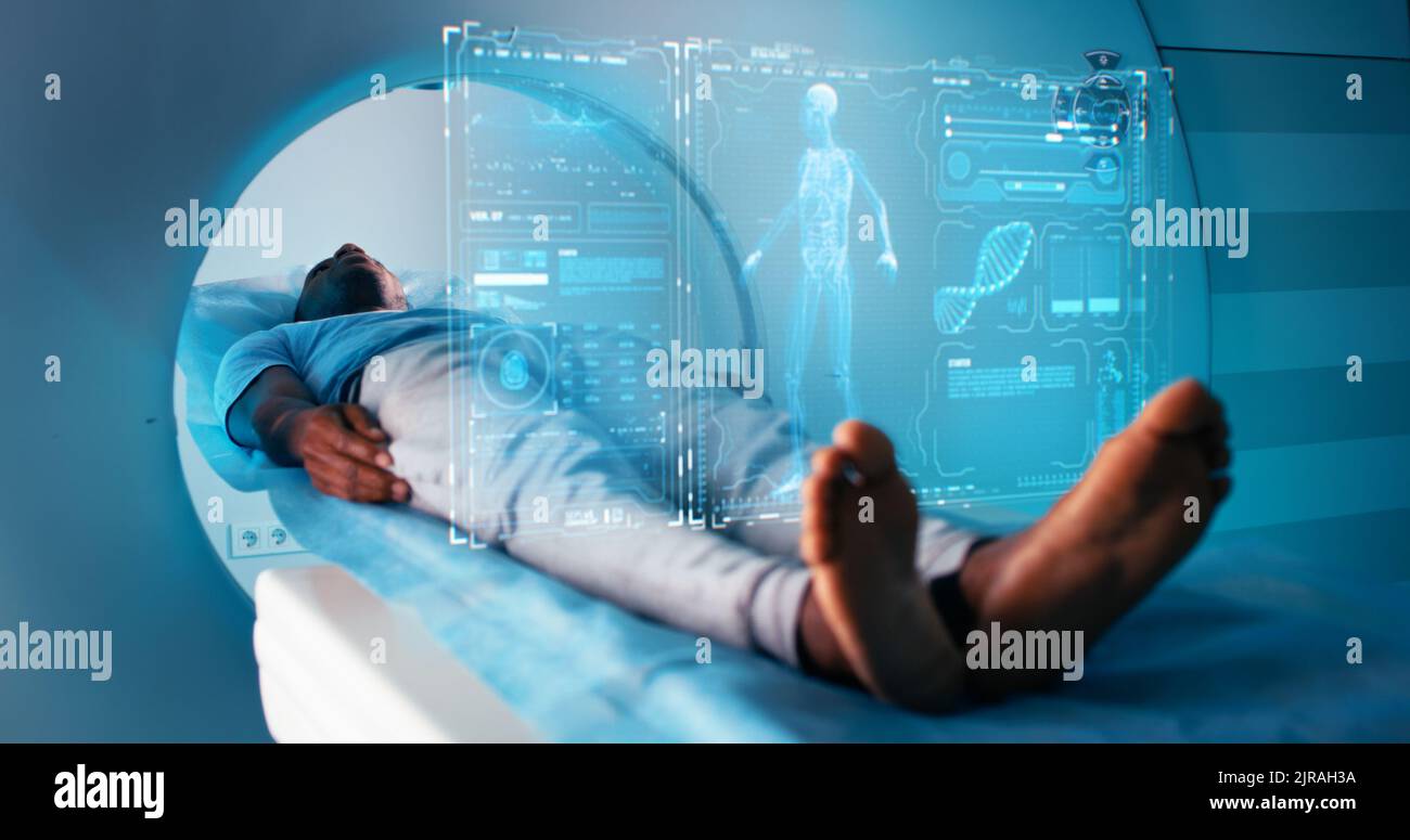 Barefoot African American man lying on table of futuristic CT machine ...