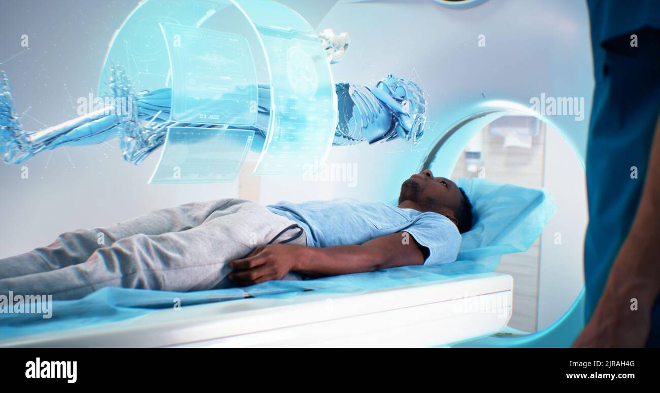 African American male patient lying on table of CT machine under 3D ...