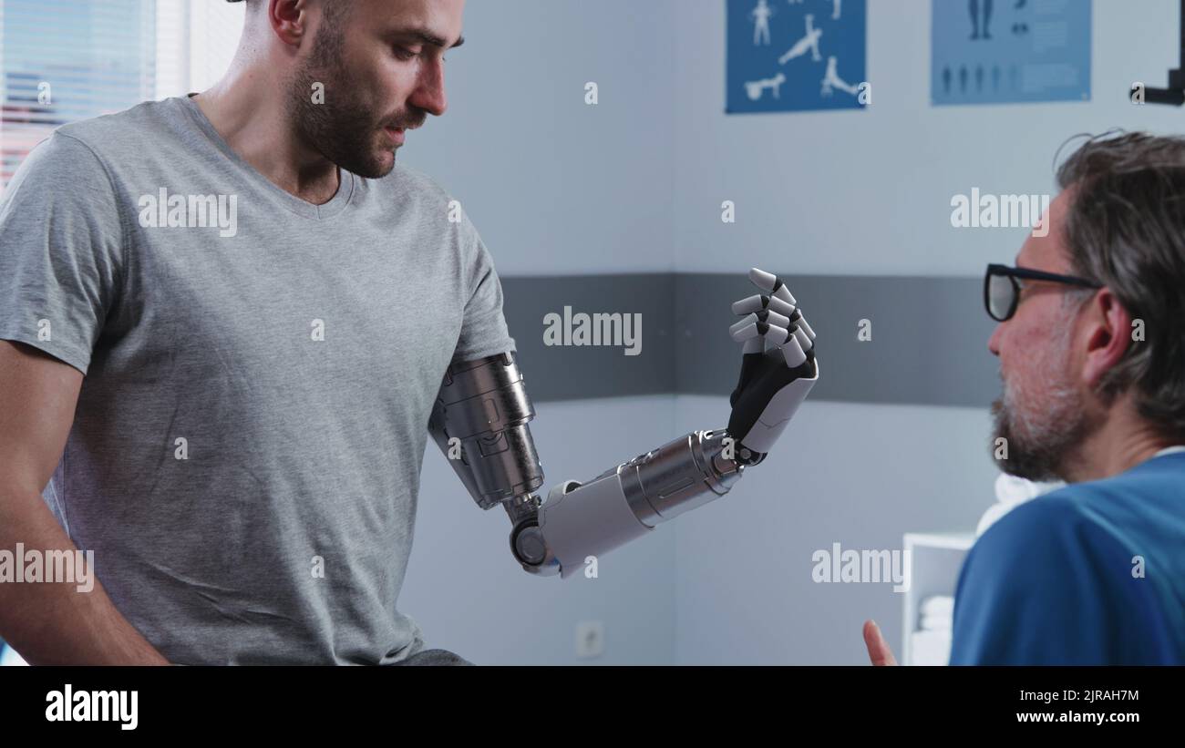 Cheerful adult man using interface on futuristic prosthetic arm and ...