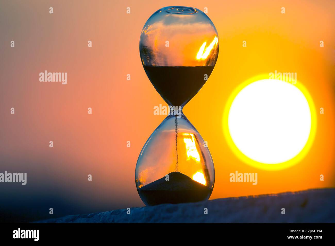 Hourglass on the background of a sunset. The value of time in life. An ...