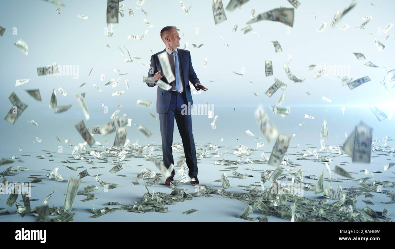 Zoom in view of happy middle aged entrepreneur dancing under falling ...