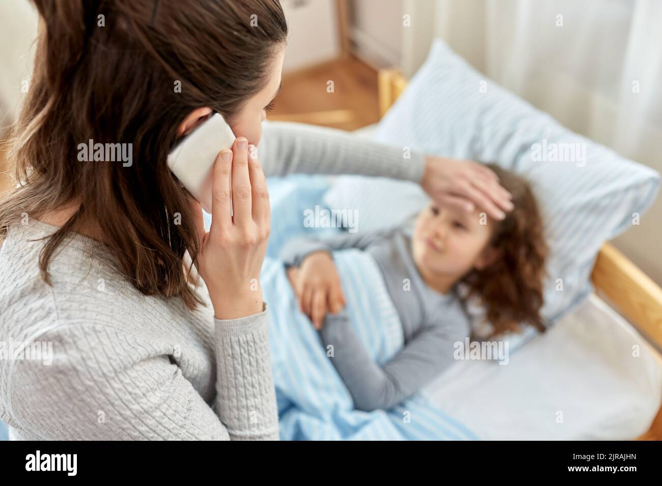 ill daughter and mother calling on phone at home Stock Photo - Alamy