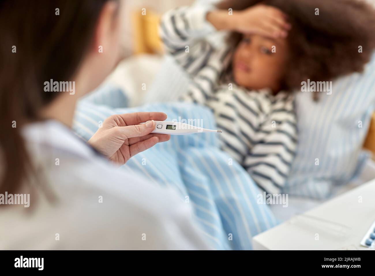 doctor measuring sick girl's temperature Stock Photo - Alamy