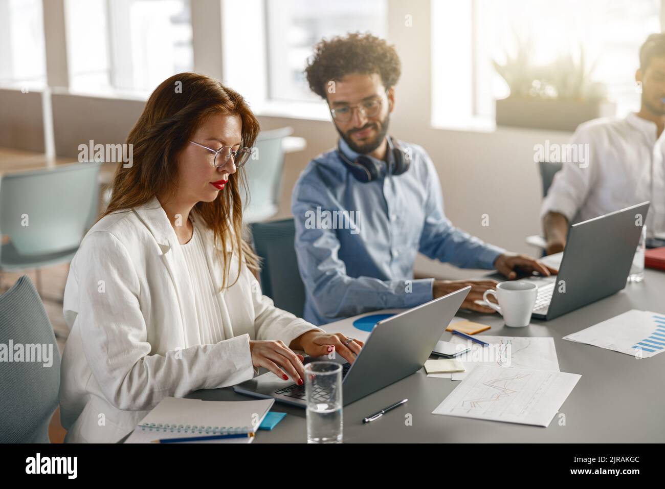 Group of young diverse coworkers analyzing sales report while working ...