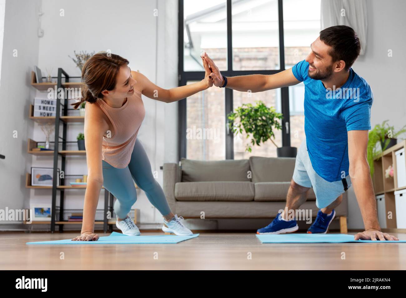happy couple make high five in side plank at home Stock Photo - Alamy