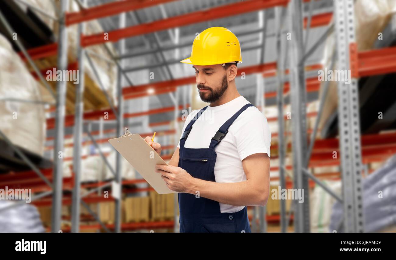male loader or worker with clipboard at warehouse Stock Photo - Alamy