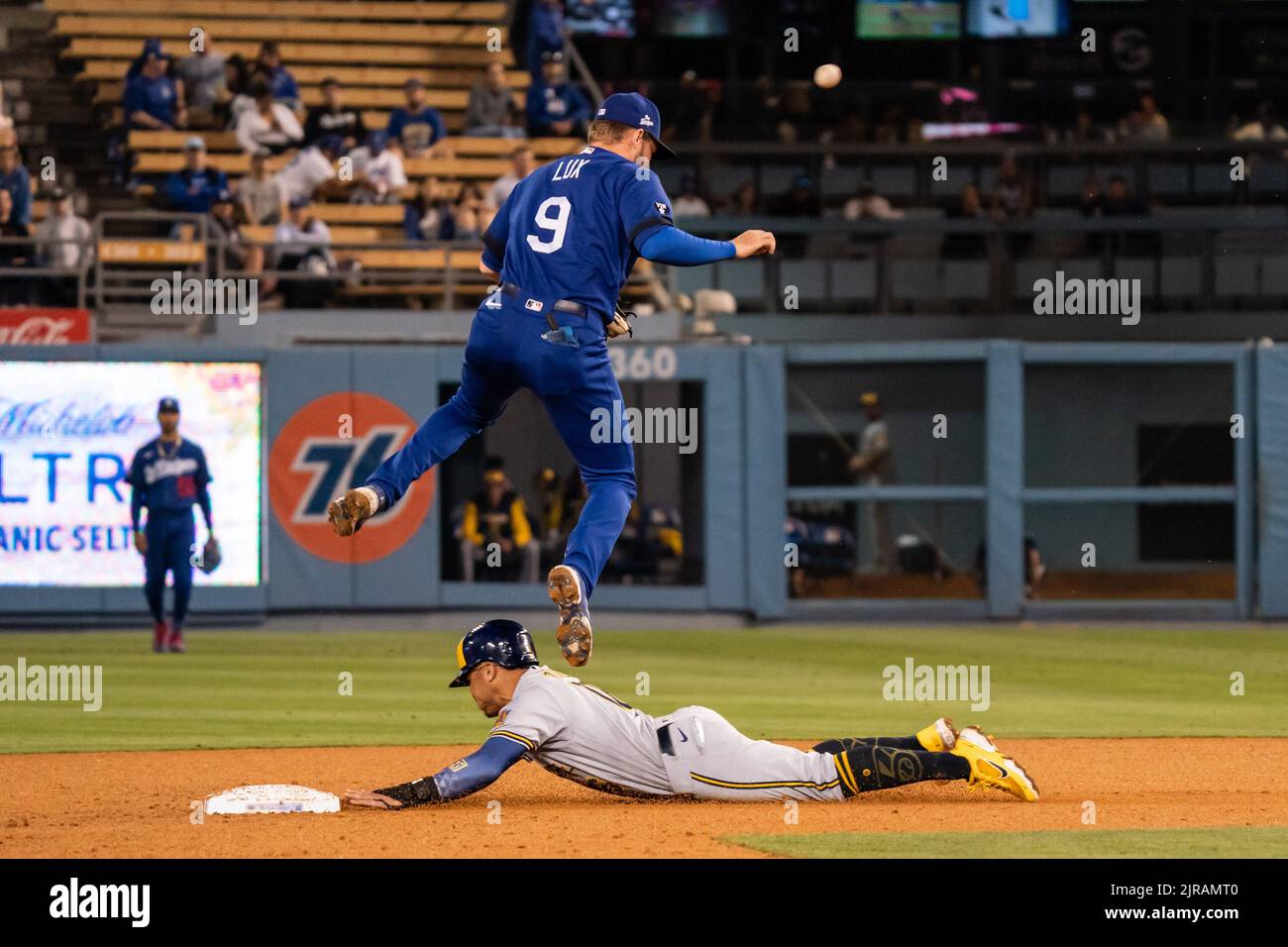 Los Angeles Dodgers second baseman Gavin Lux (9) avoids Milwaukee Brewers second baseman Kolten ...