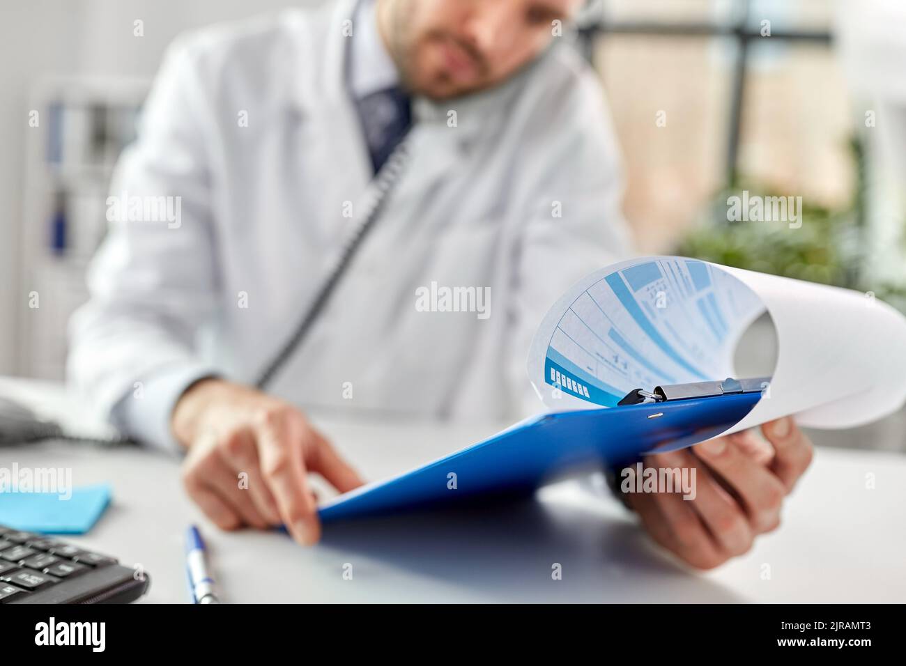 male doctor calling on desk phone at hospital Stock Photo - Alamy