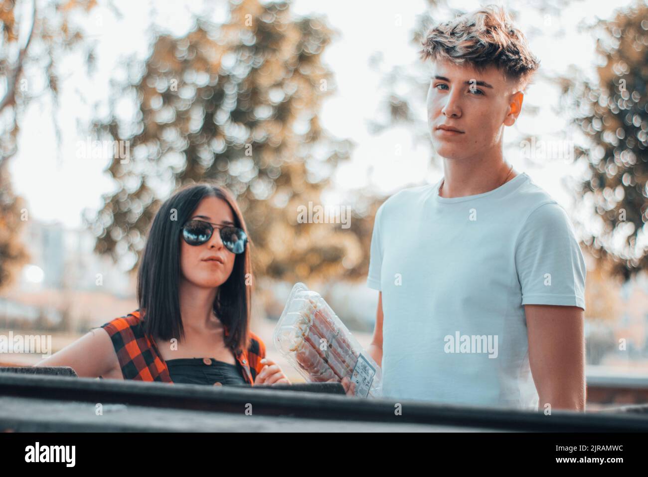 Two young Spanish friends spending time together while cooking in a ...