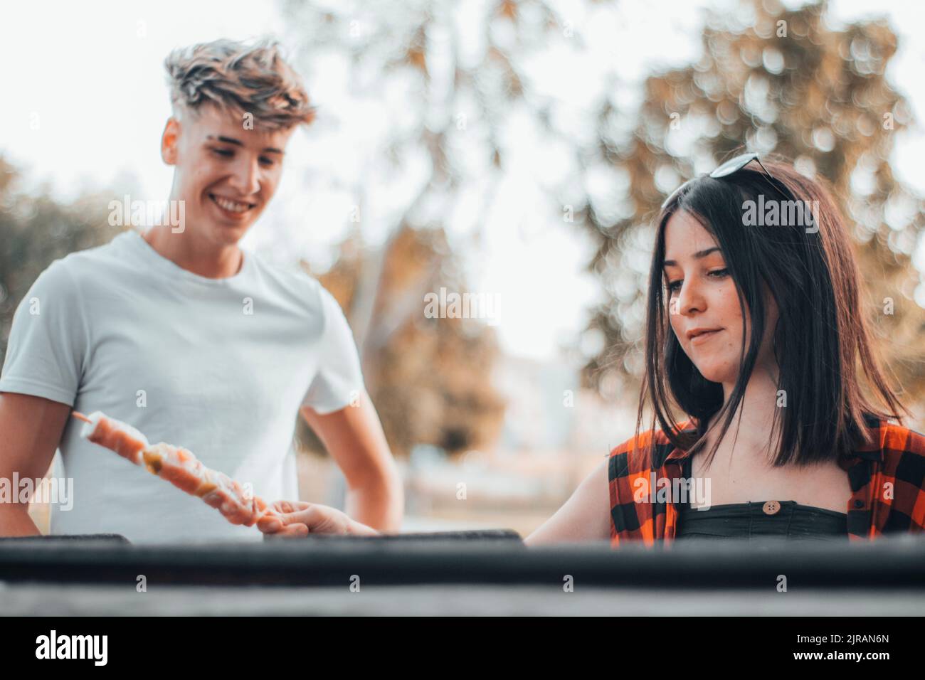 Two young Spanish friends spending time together while cooking in a ...