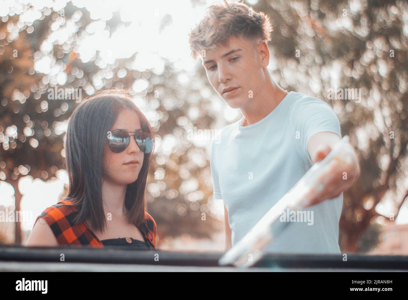 Two young Spanish friends spending time together while cooking in a ...
