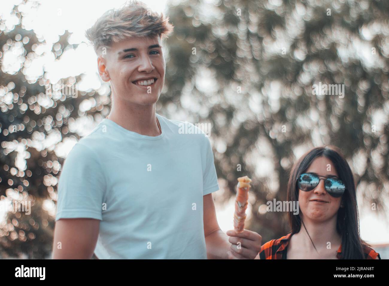 Two young Spanish friends spending time together while cooking in a ...