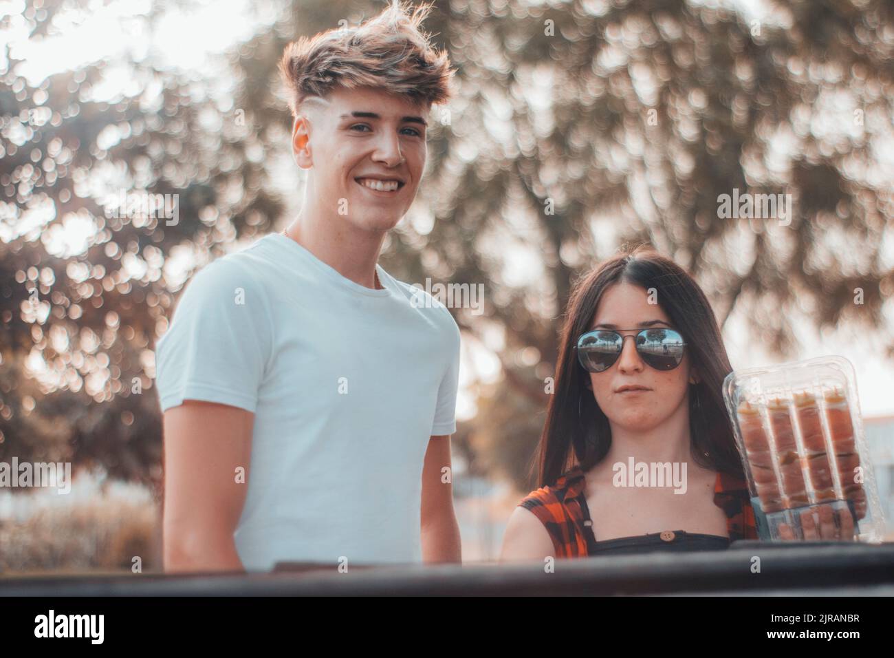 Two young Spanish friends spending time together while cooking in a ...