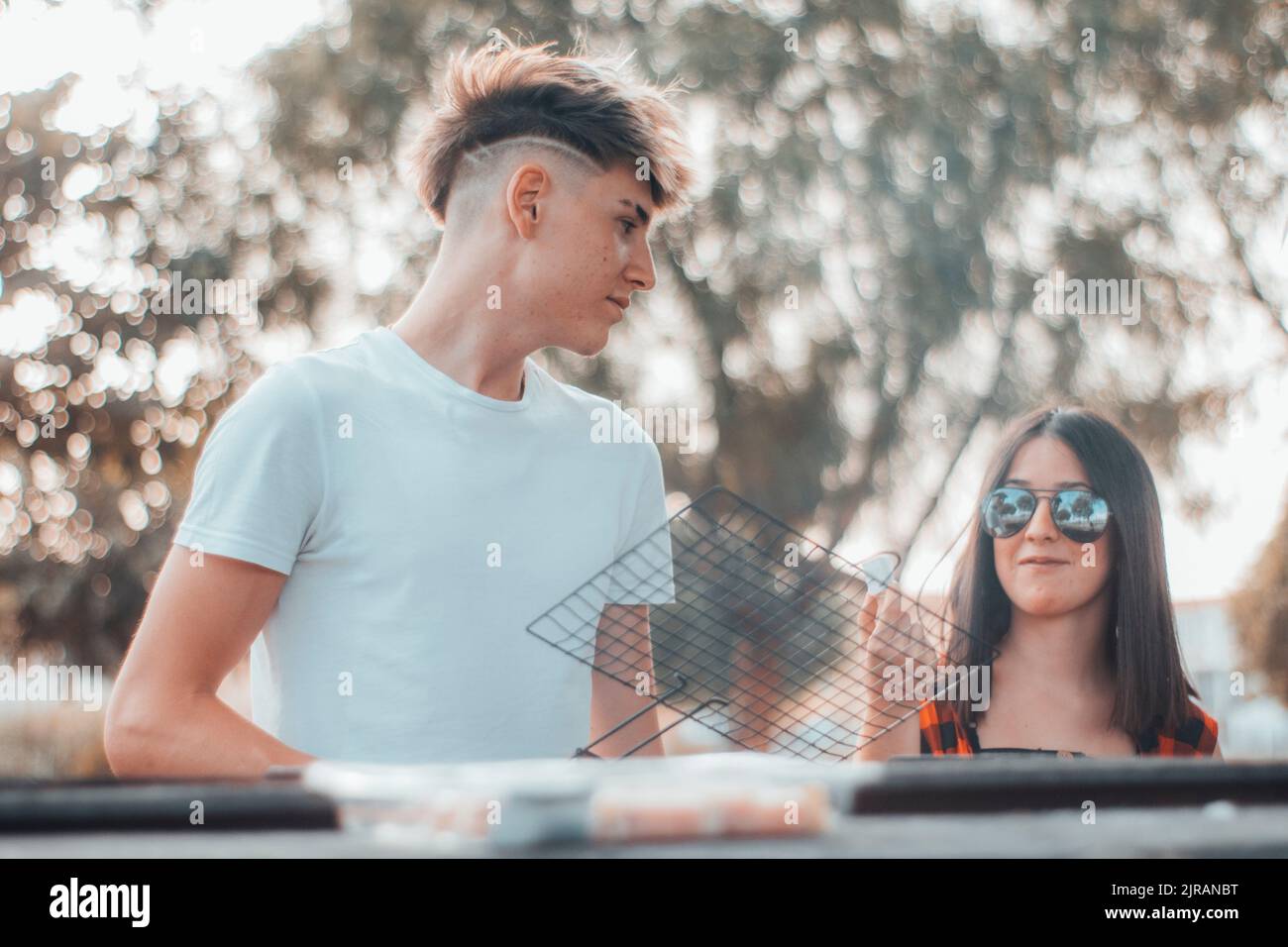 Two young Spanish friends spending time together while cooking in a ...