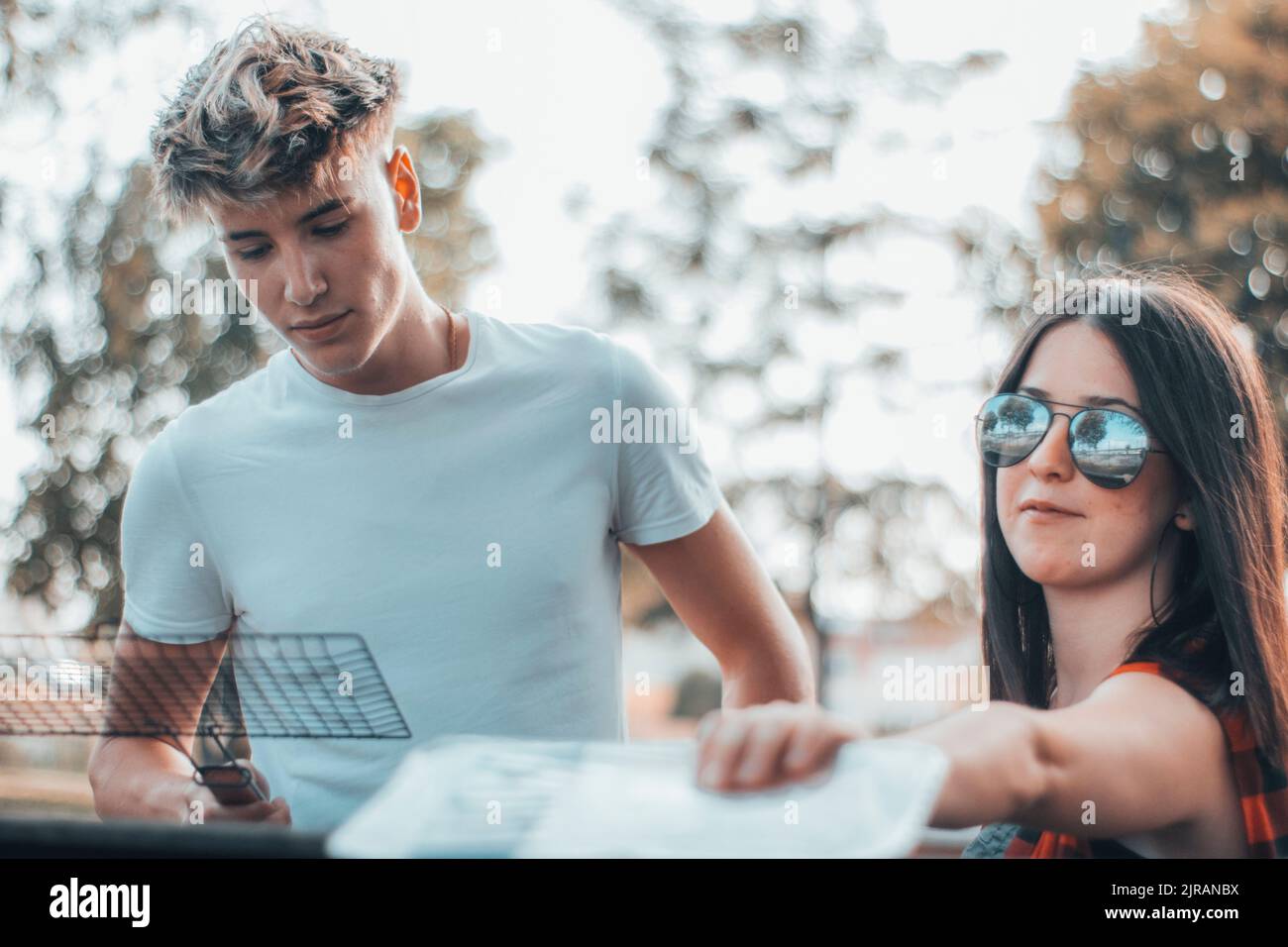 Two young Spanish friends spending time together while cooking in a ...