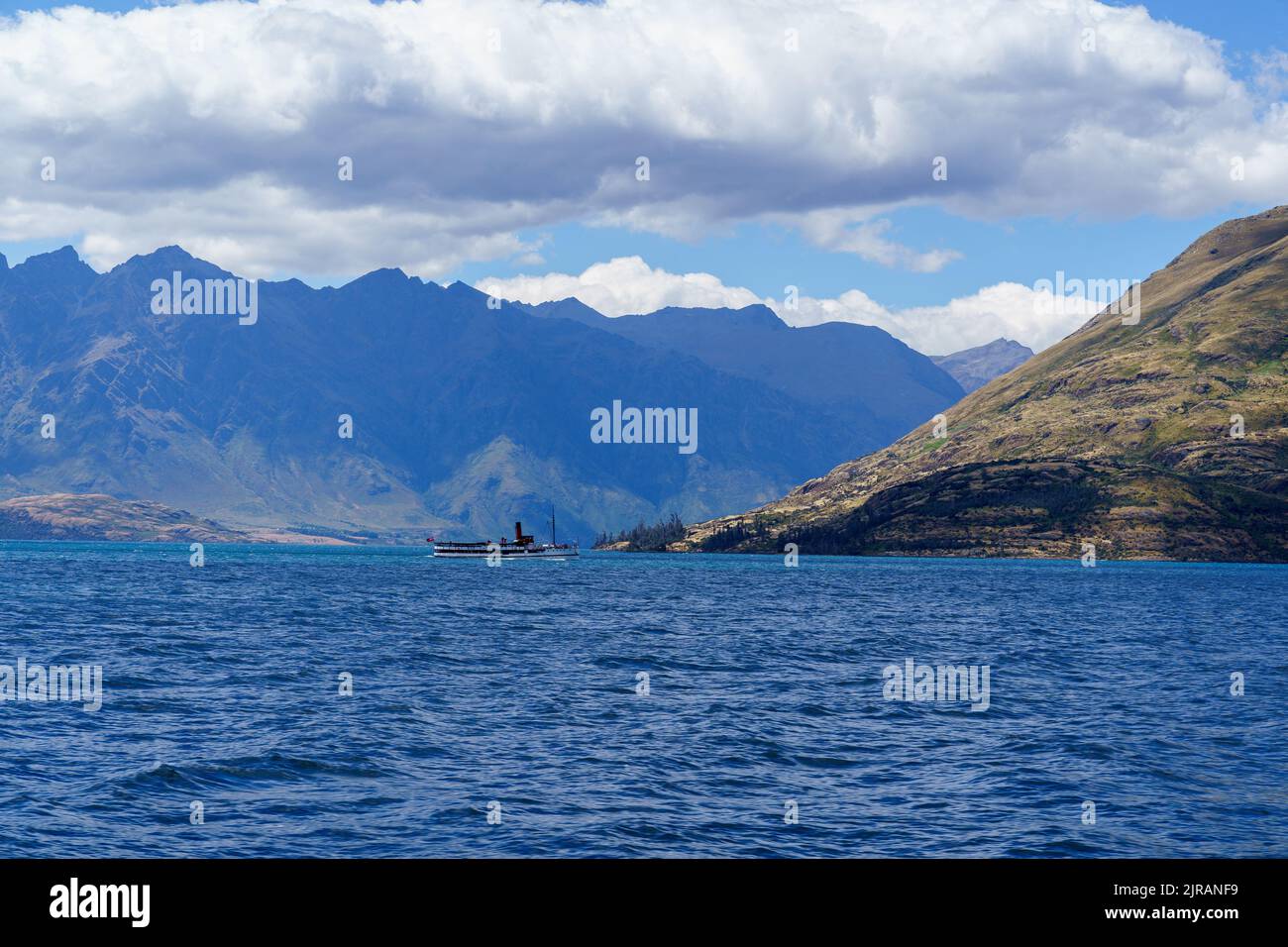 A large boat on the beautiful blue waters of Lake Wakatipu in ...
