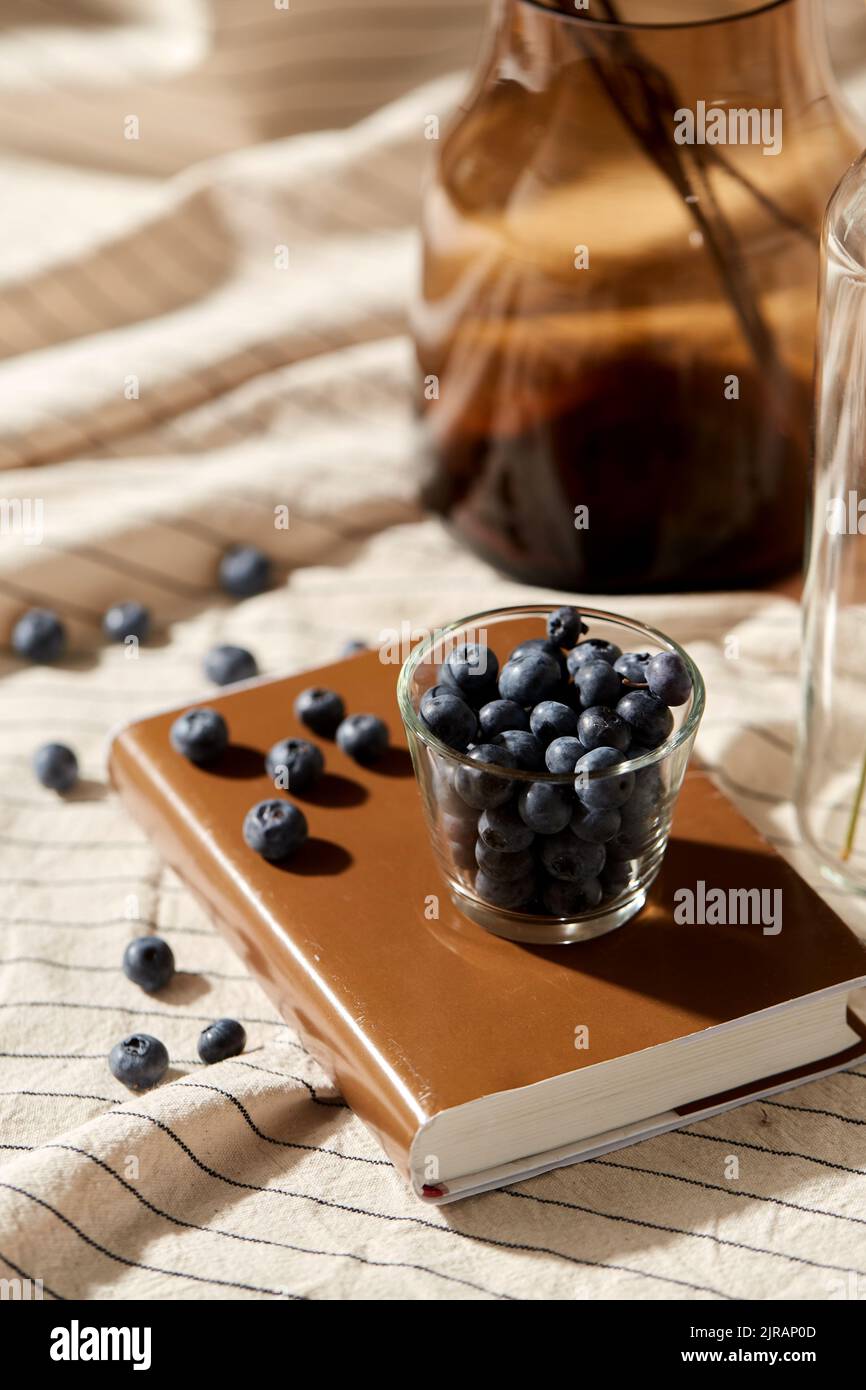 cup of blueberry, book and dried flowers in vases Stock Photo - Alamy