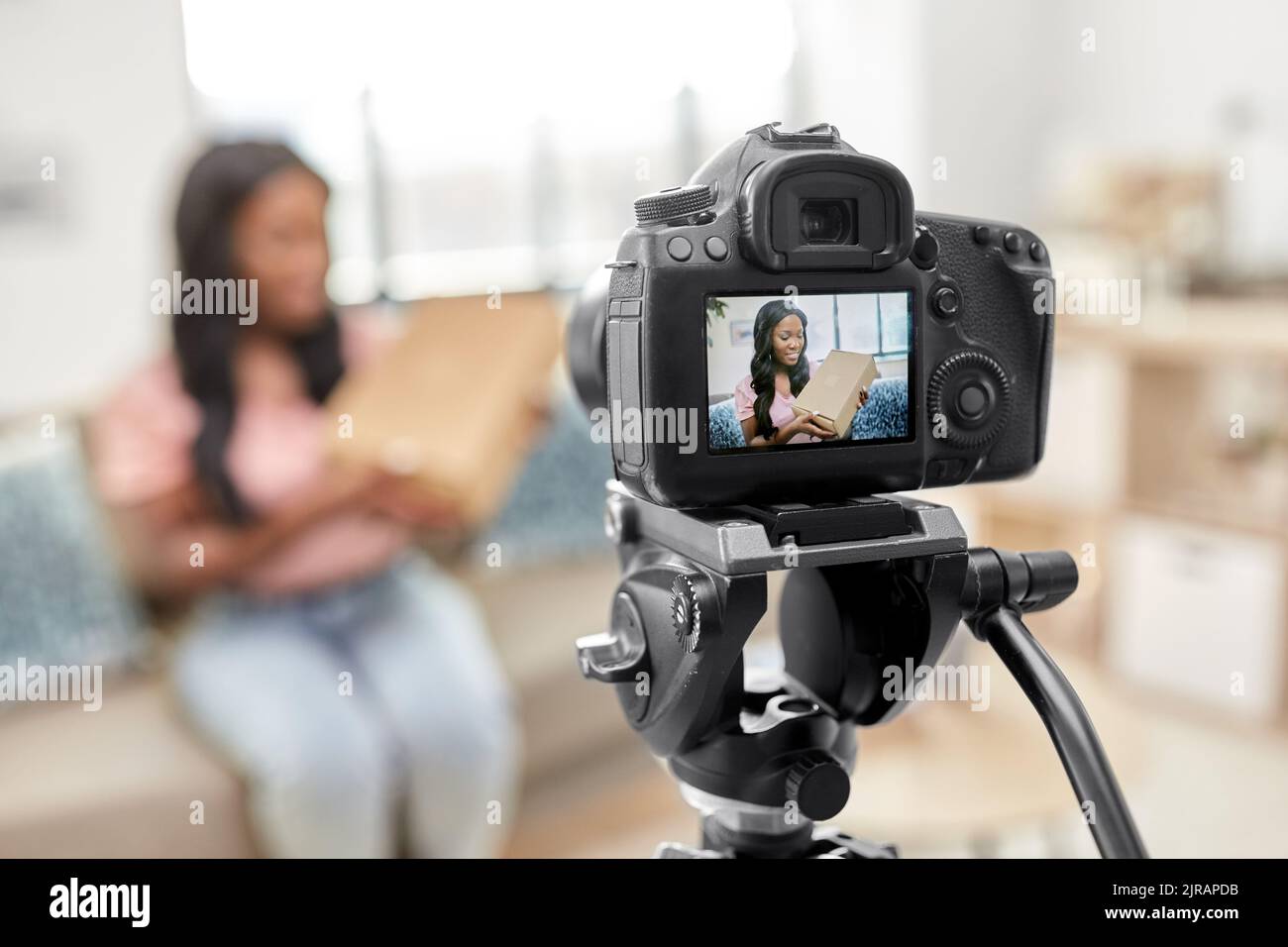 female video blogger with camera and box at home Stock Photo - Alamy
