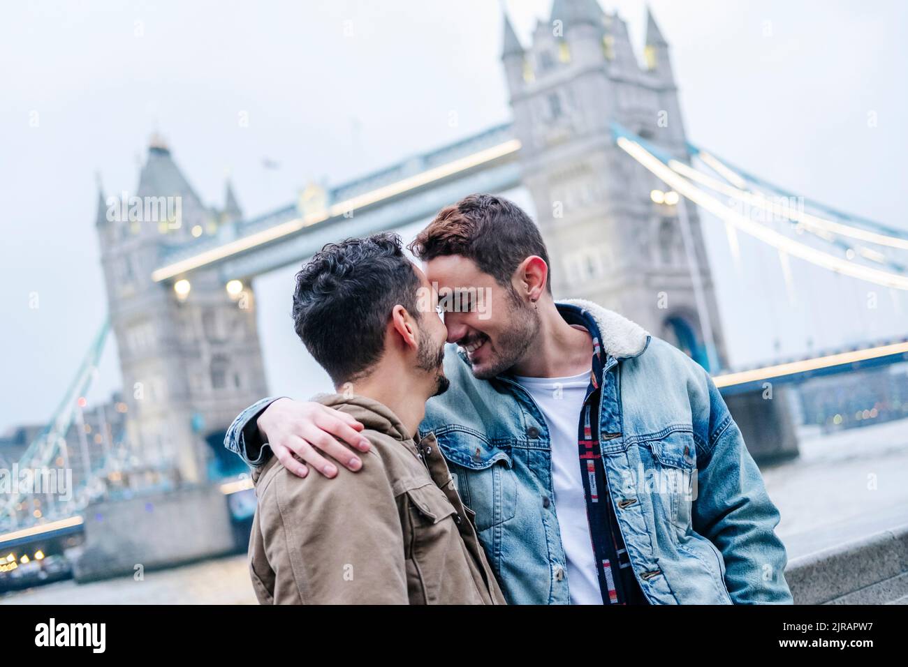 London, United Kingdom, A couple of guys embracing in front of Tower ...