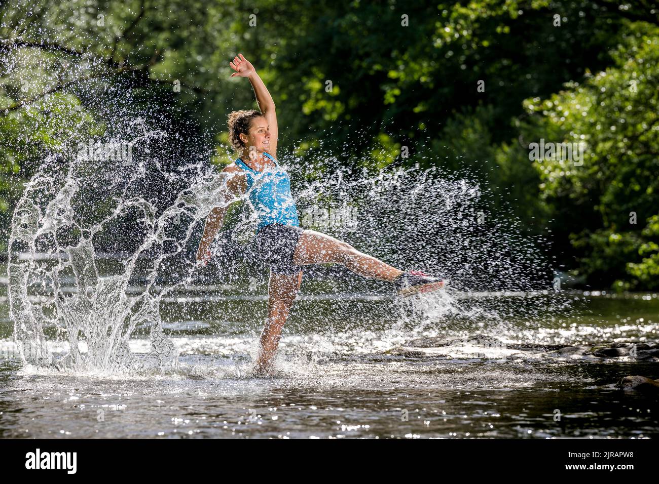 Young woman splashing water standing in river Stock Photo - Alamy