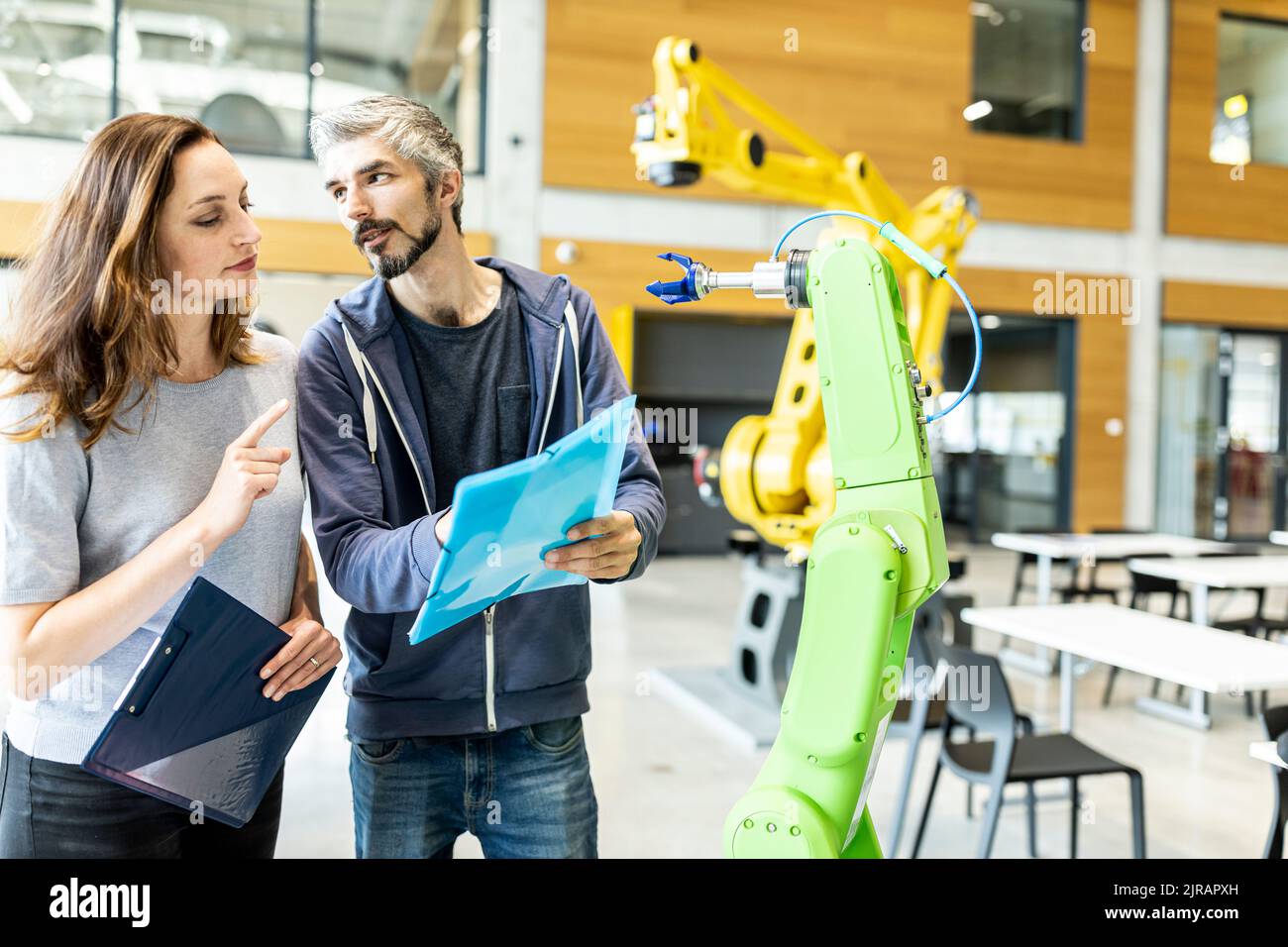 Technicians having meeting in front of industrial robot Stock Photo - Alamy