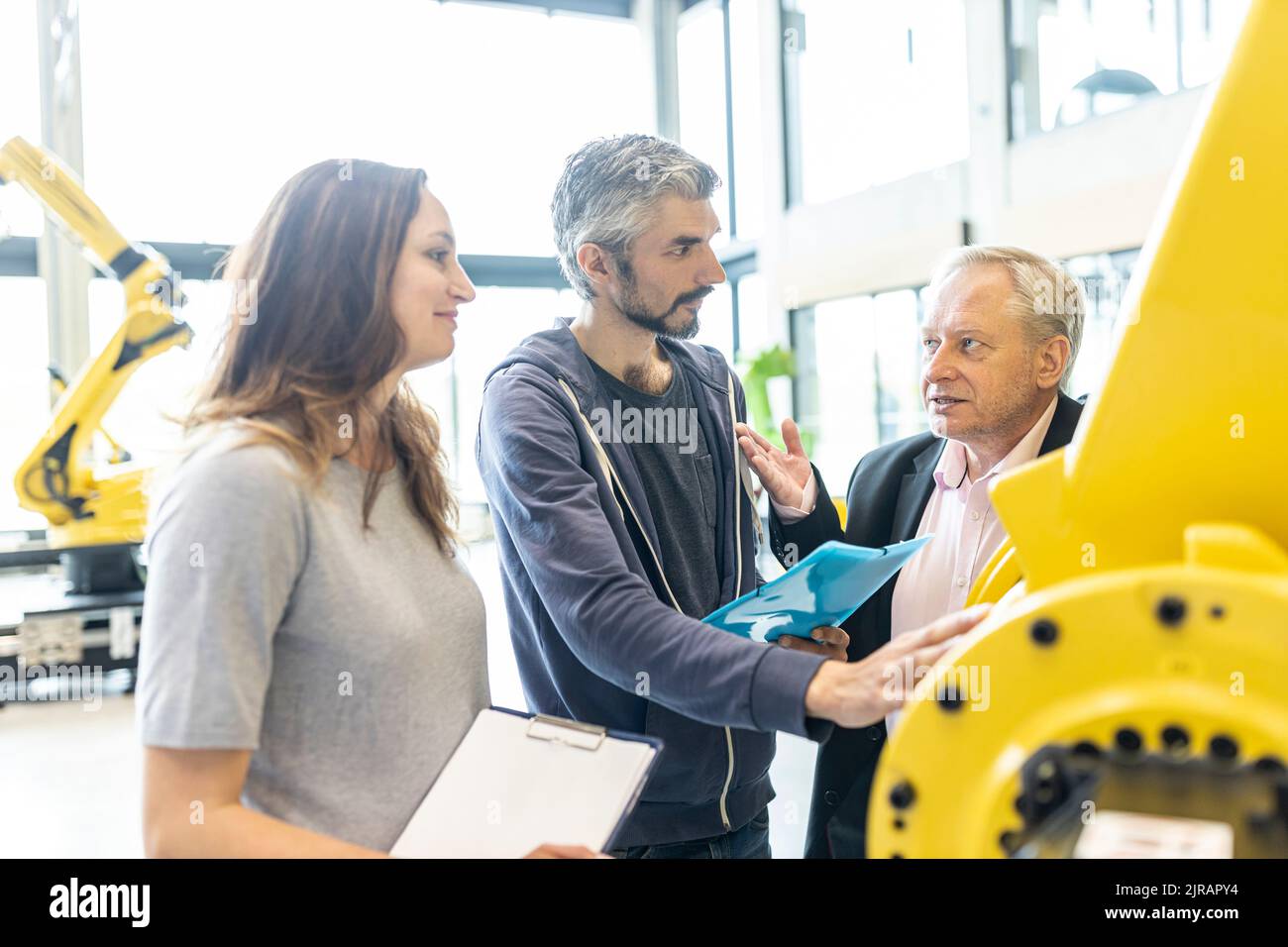 Senior customer getting advise on industrial robot from expert staff ...
