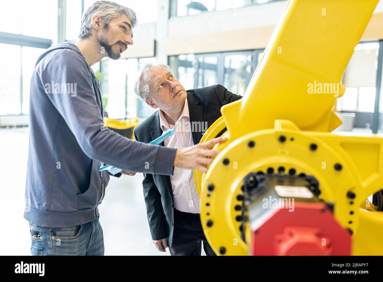 Senior customer getting advise on industrial robot from expert staff ...
