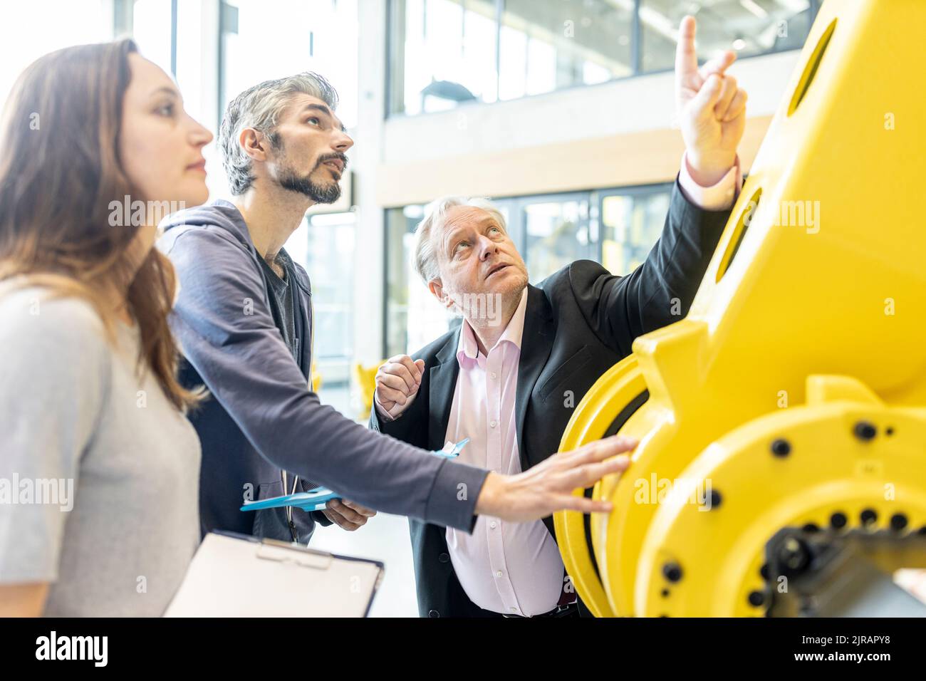 Senior customer getting advise on industrial robot from expert staff ...