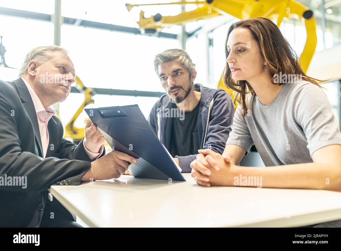 Coworkers having meeting with boss in industrial factory Stock Photo ...
