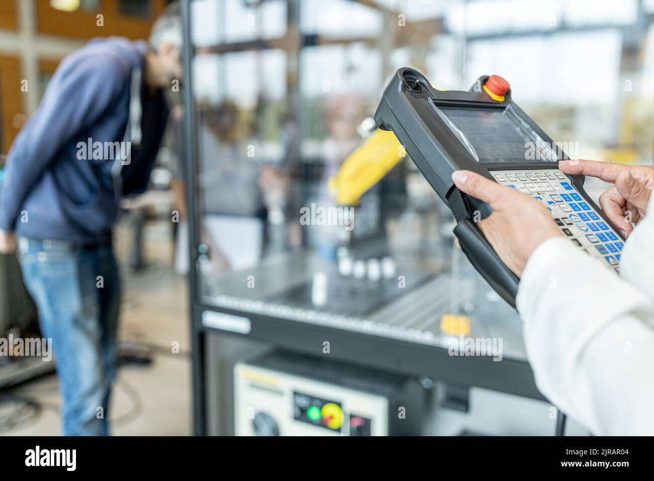Woman in factory using control of industrial robot Stock Photo - Alamy