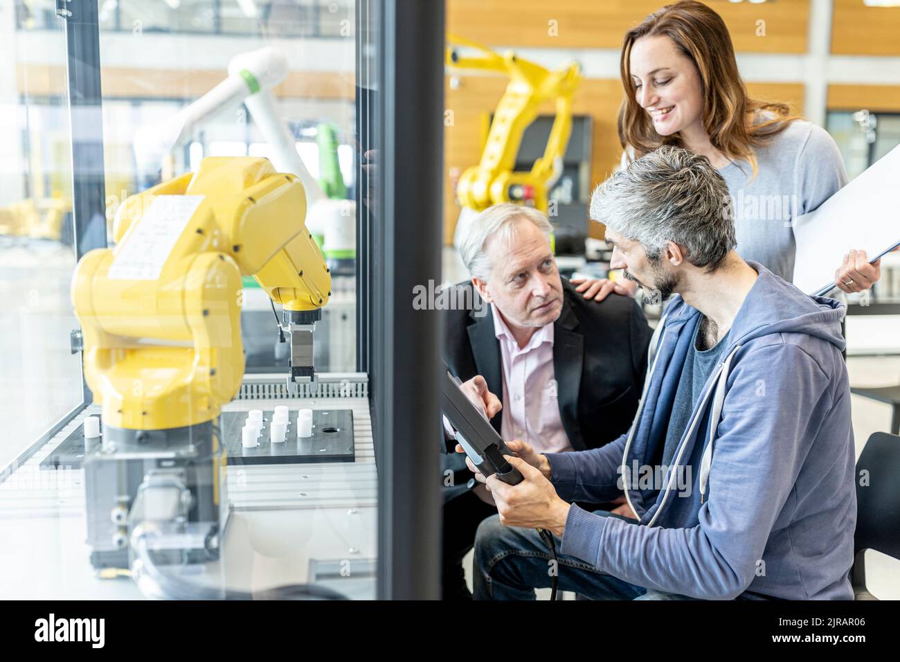 Senior customer getting advise on industrial robot from expert staff ...