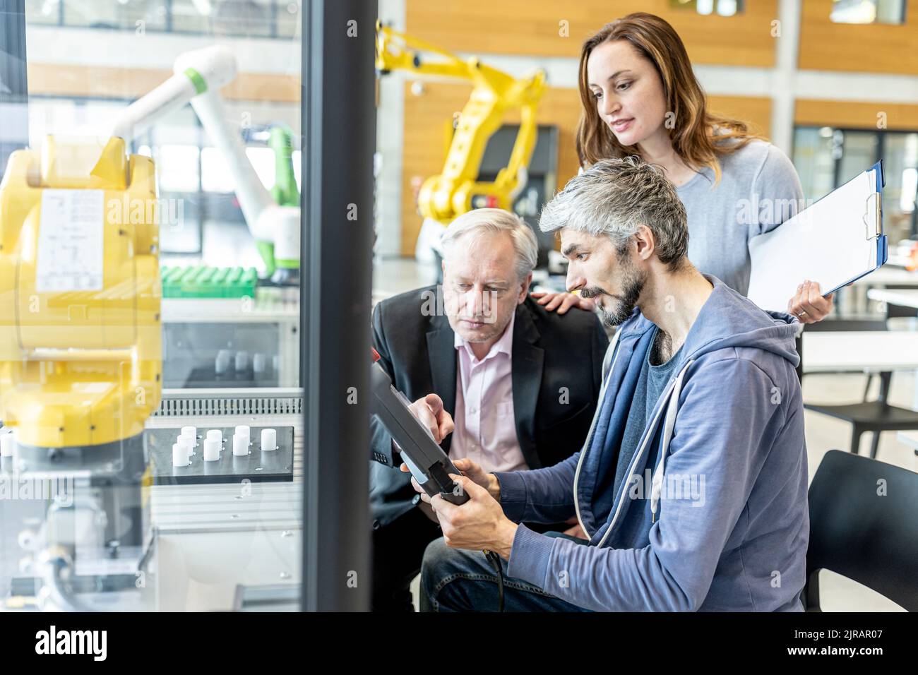 Senior customer getting advise on industrial robot from expert staff ...