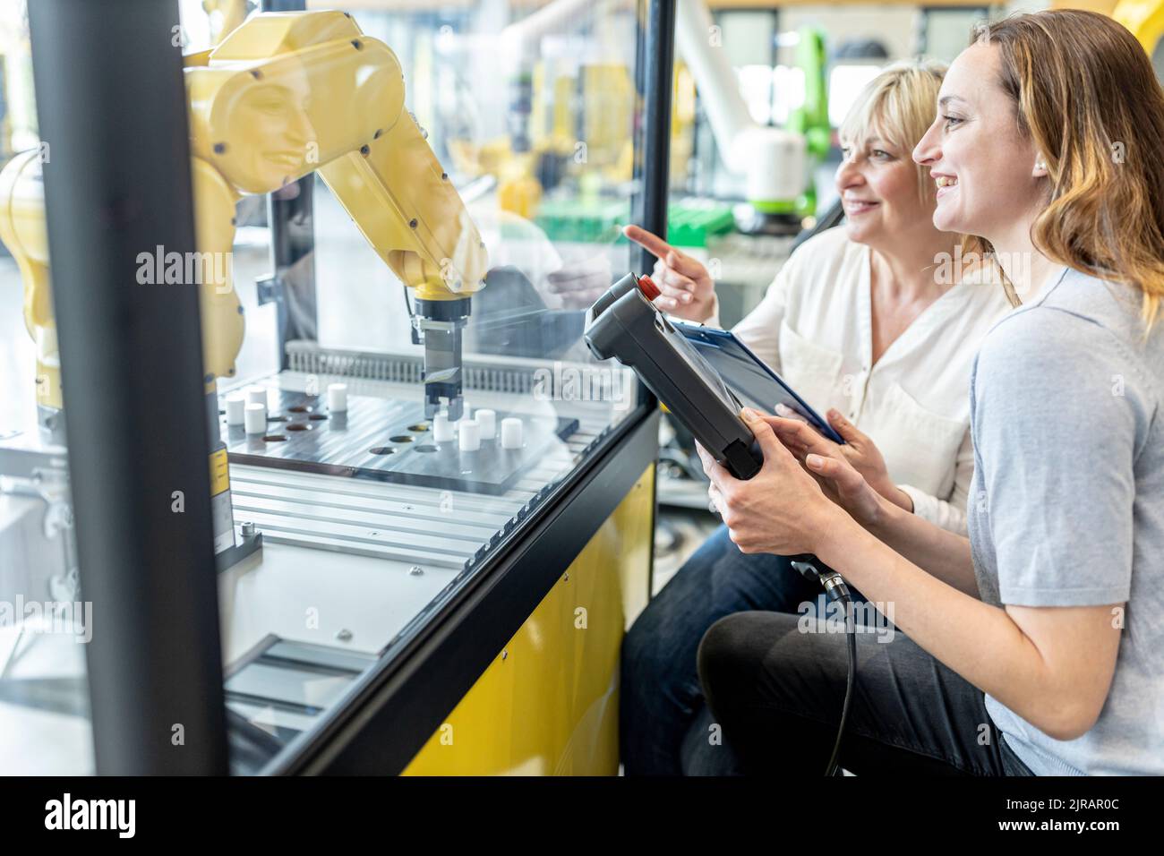 Women in factory using control of industrial robot Stock Photo - Alamy