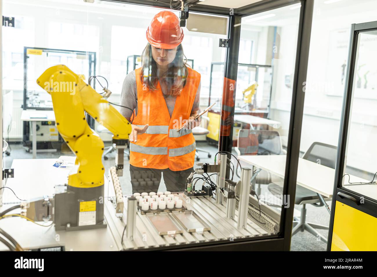 Female skilled worker training robotic arm Stock Photo - Alamy