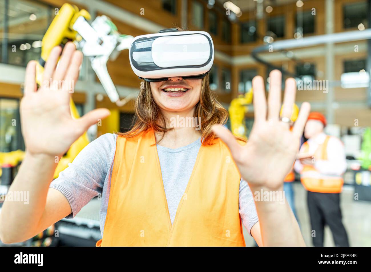 Industrial worker in robotics factory using virtual reality simulator ...