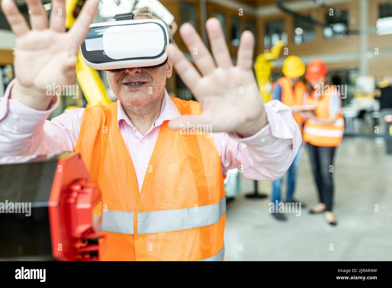 Industrial worker in robotics factory using virtual reality simulator ...