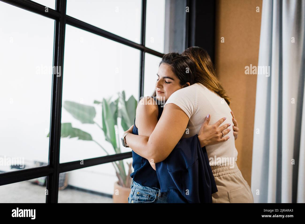Businesswomen hugging each other in office Stock Photo - Alamy