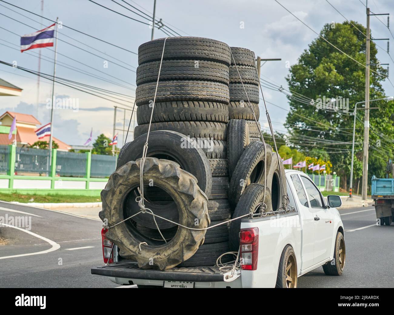 An overloaded pickup truck carrying used rubber tires for recycling ...