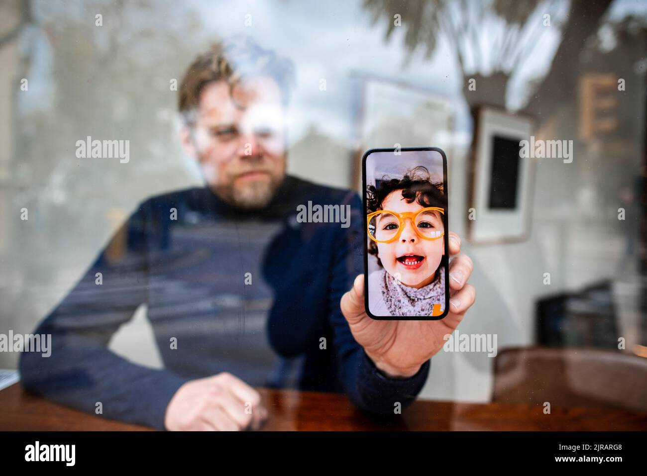 Businessman showing daughter's face on video call through smart phone ...