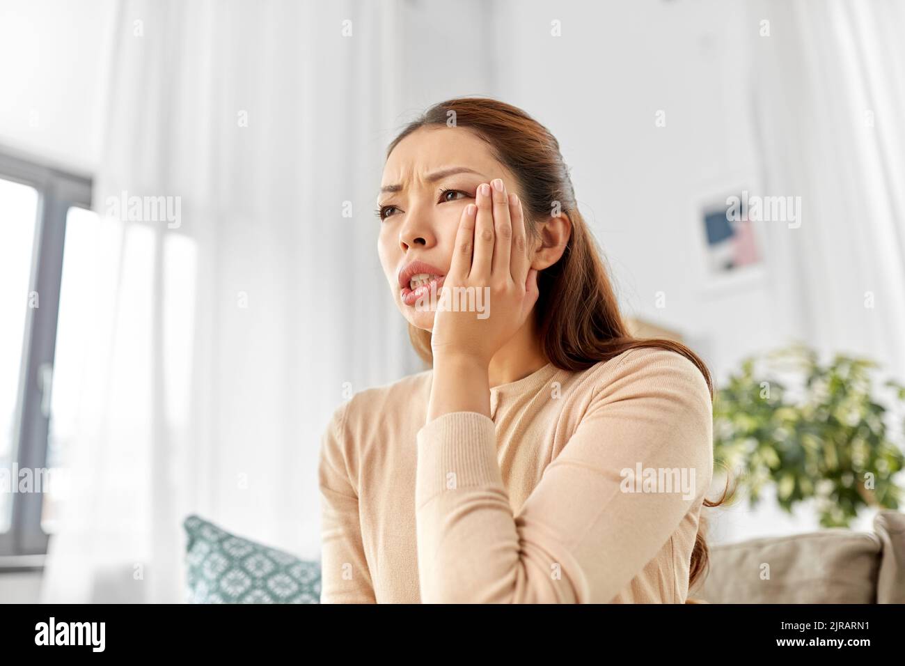 asian woman suffering from toothache at home Stock Photo - Alamy