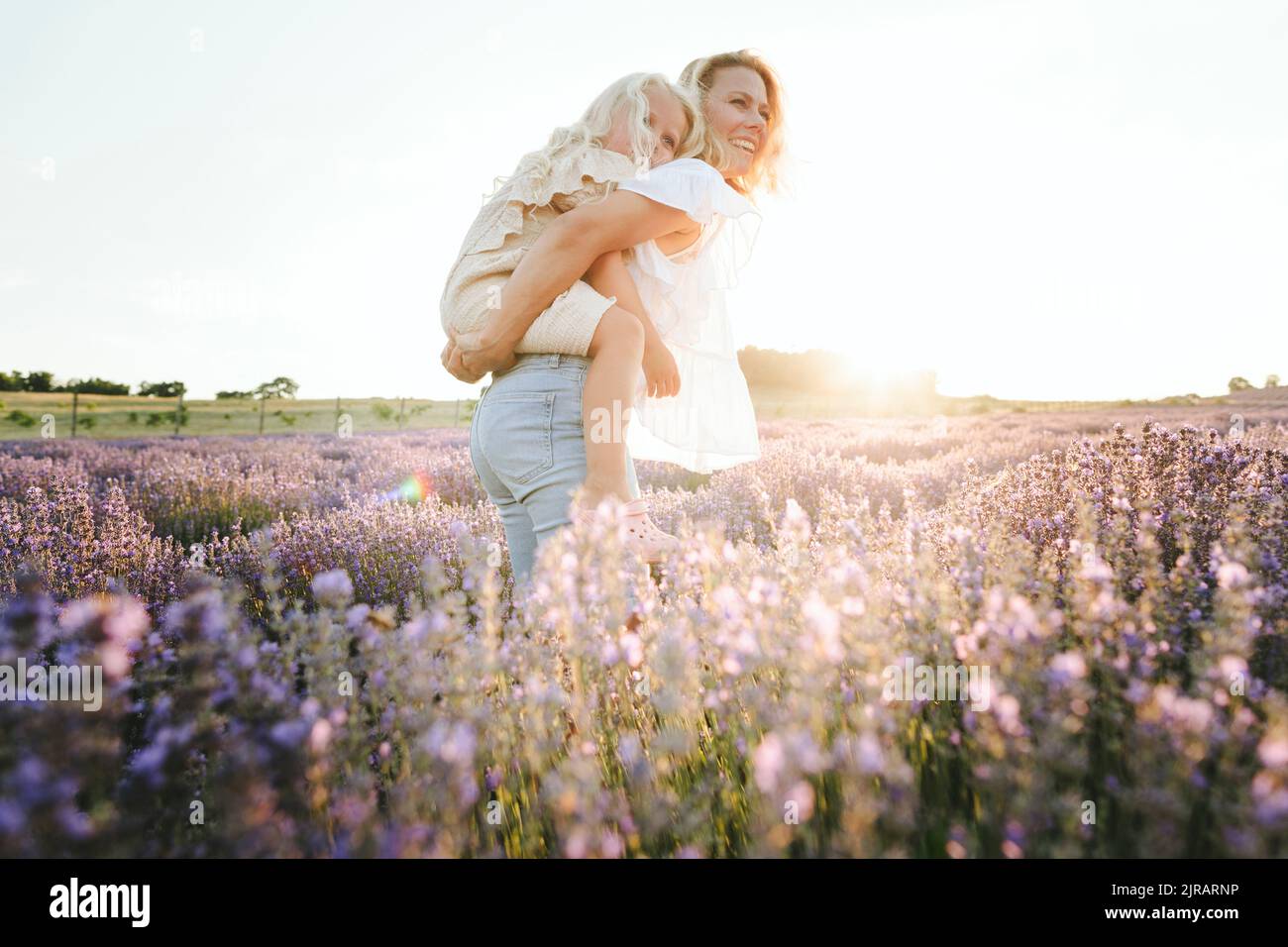 Happy mother giving piggyback ride to daughter Stock Photo - Alamy