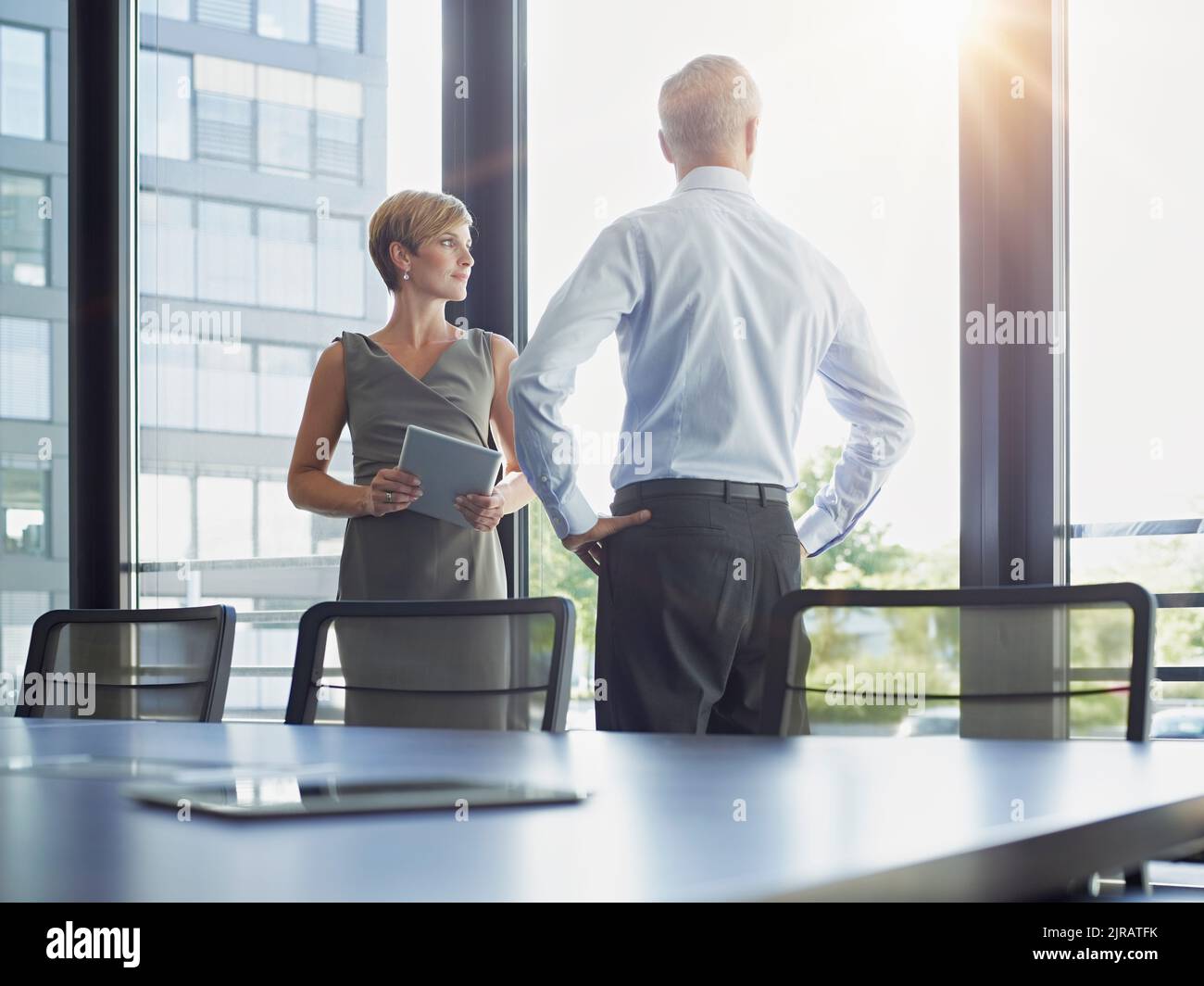 Business colleagues looking out through window from board room Stock ...