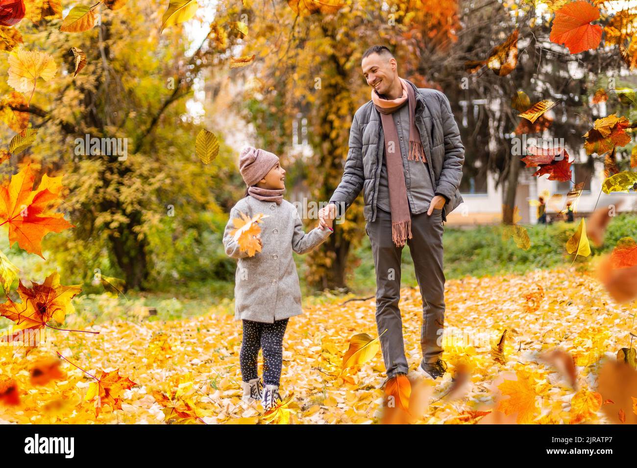 Happy family father and child daughter on a walk in the autumn leaf ...